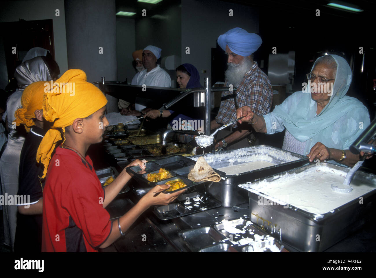 SIKH volunteers serve langar or vegetarian lunch in the Gurdwara ...