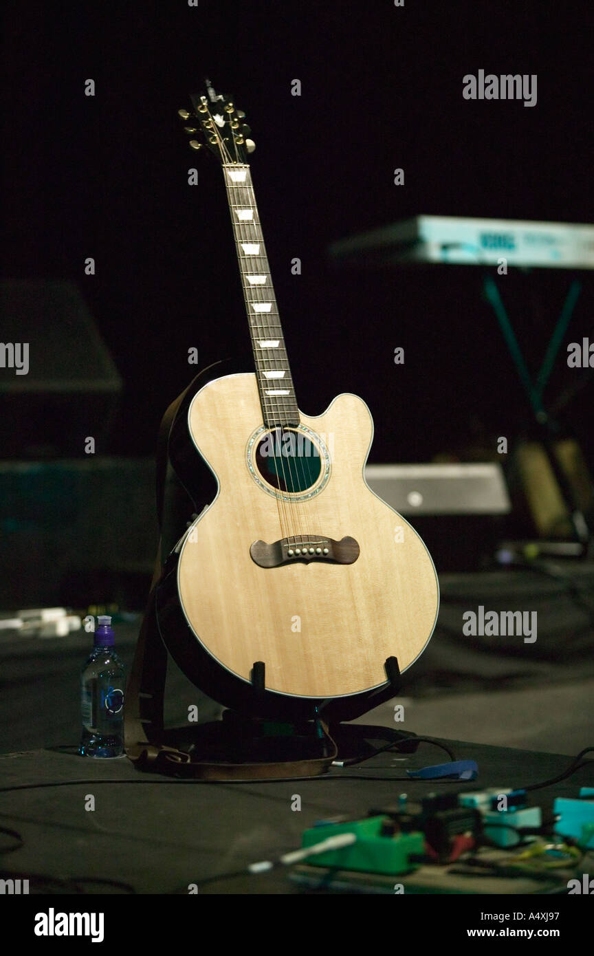 Acoustic gutair resting on guitar stand Stock Photo - Alamy