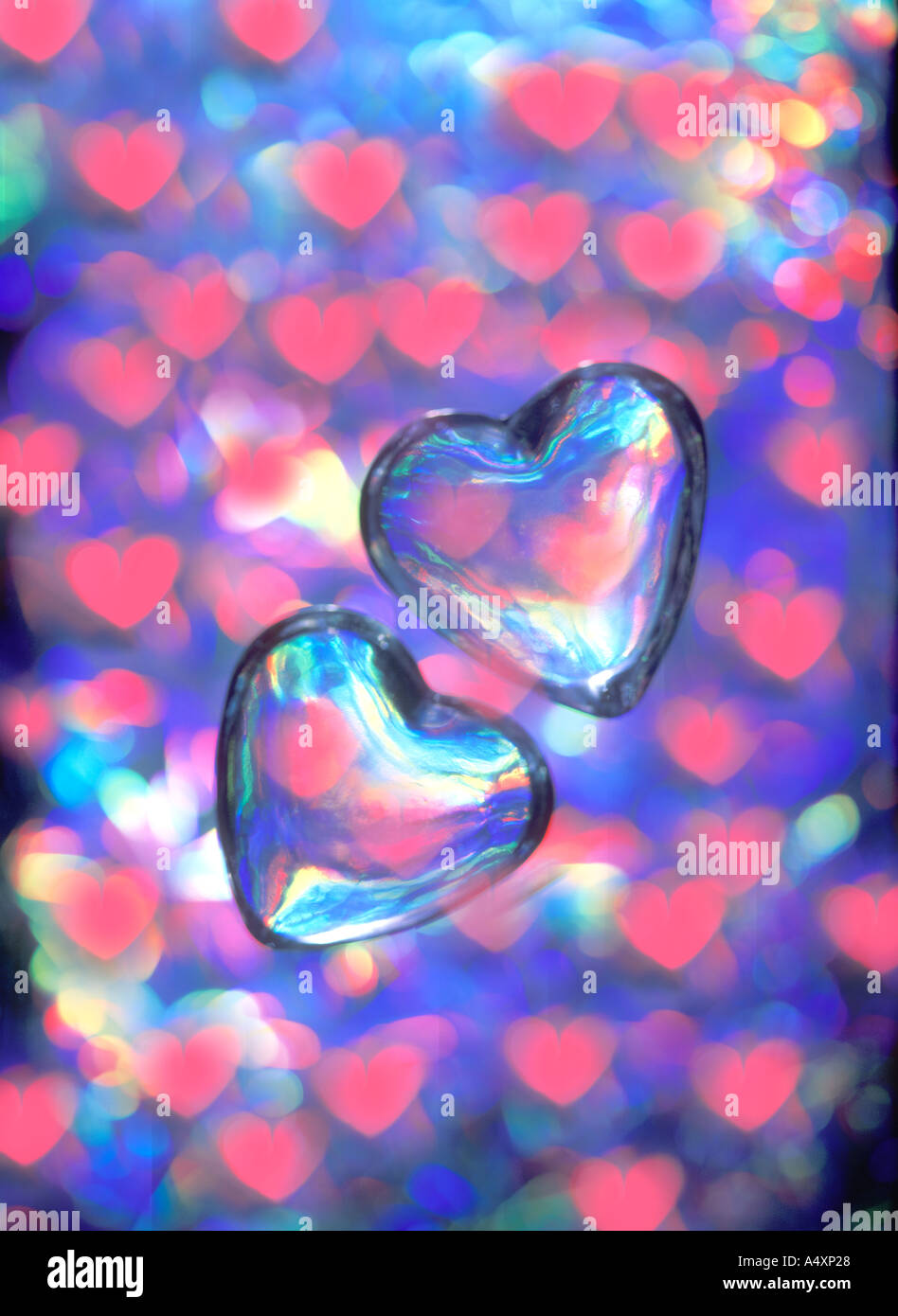 Two floating transparent glass hearts with small pink hearts in ...