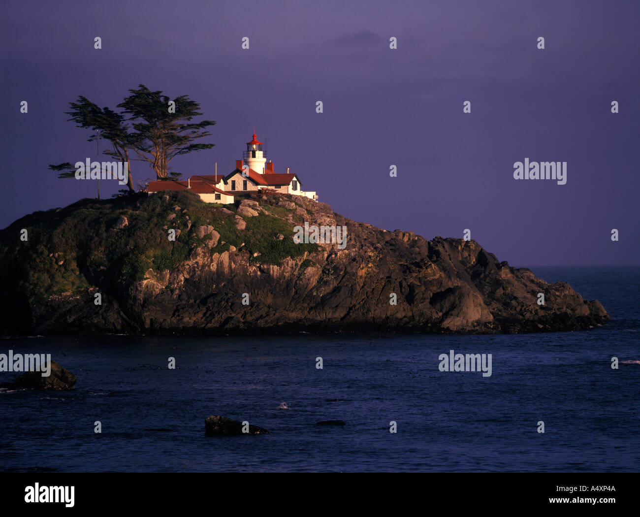 Battery Point Lighthouse on a tidal island shines in a ray of light ...