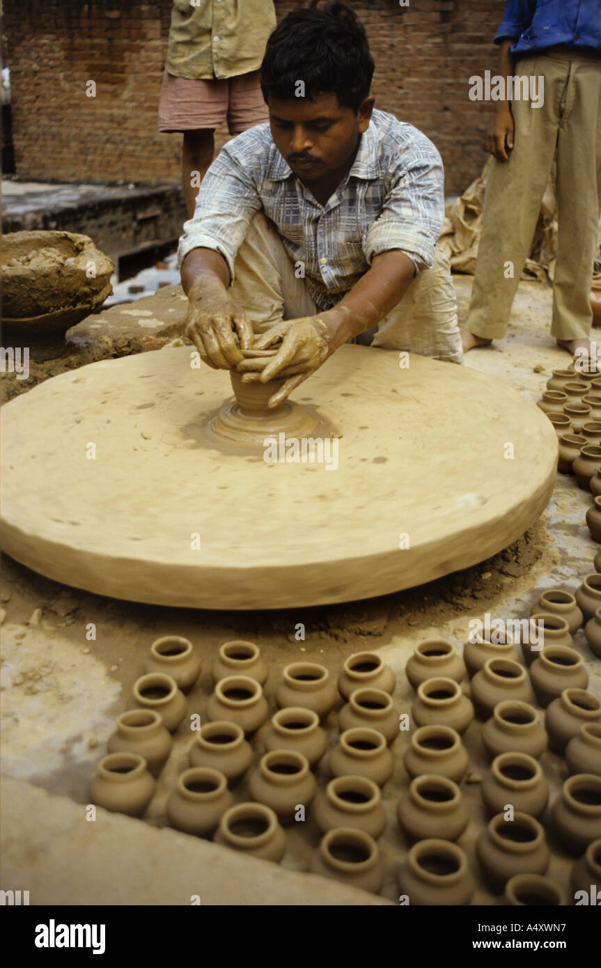 Craftsman moulding a pot on a potters wh Stock Photo - Alamy