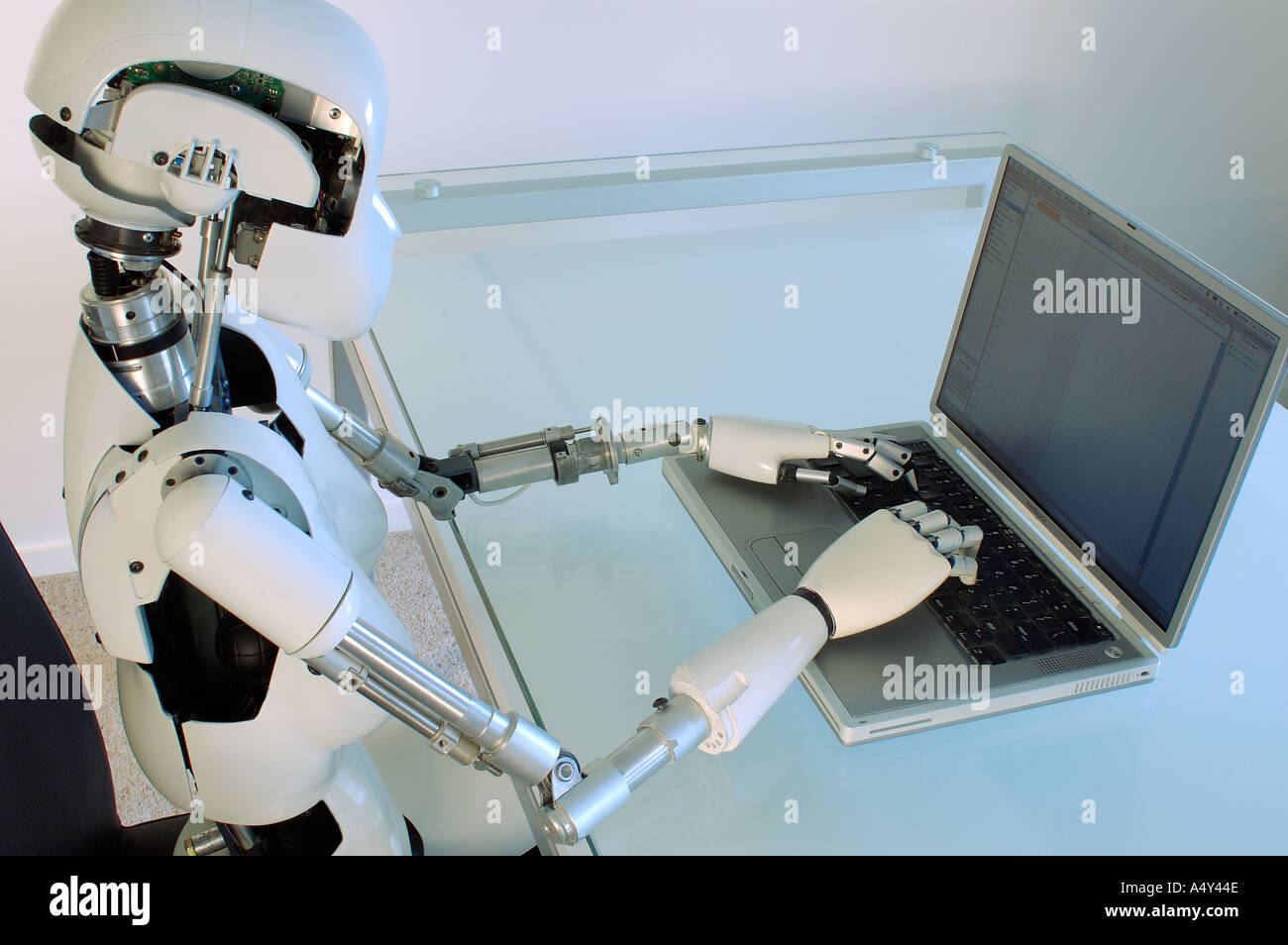 Female humanoid robot operating a laptop computer Stock Photo - Alamy