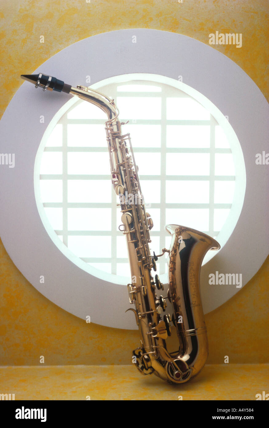 Saxophone in front of round window Stock Photo - Alamy