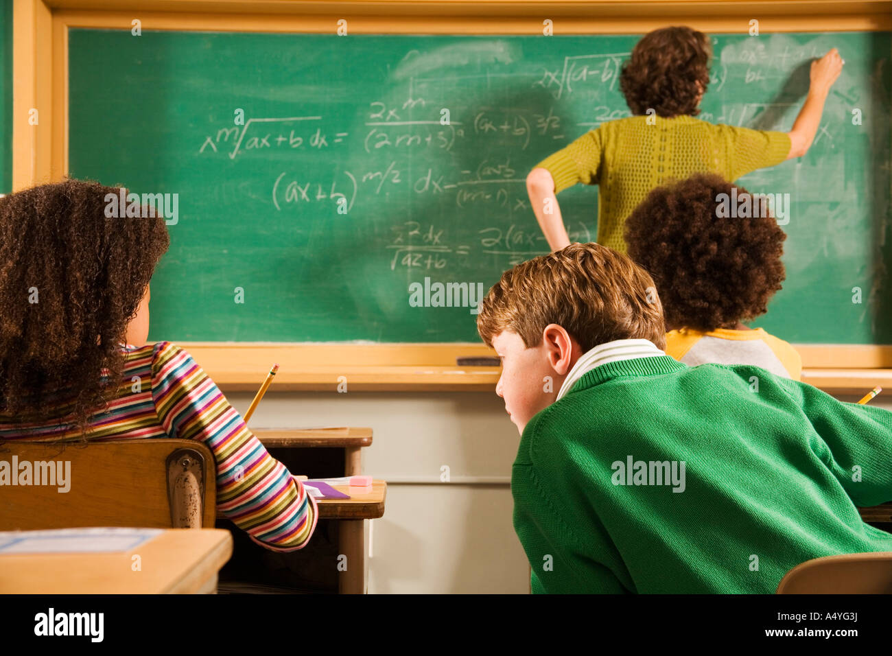 Boy looking at girl’s paper in classroom Stock Photo - Alamy