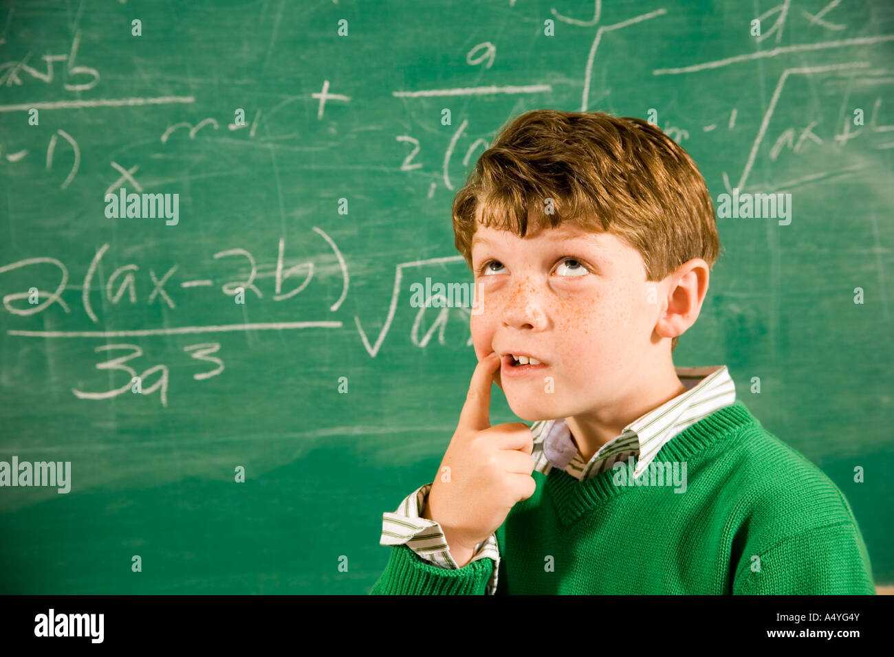 Boy thinking in front of math on blackboard Stock Photo - Alamy