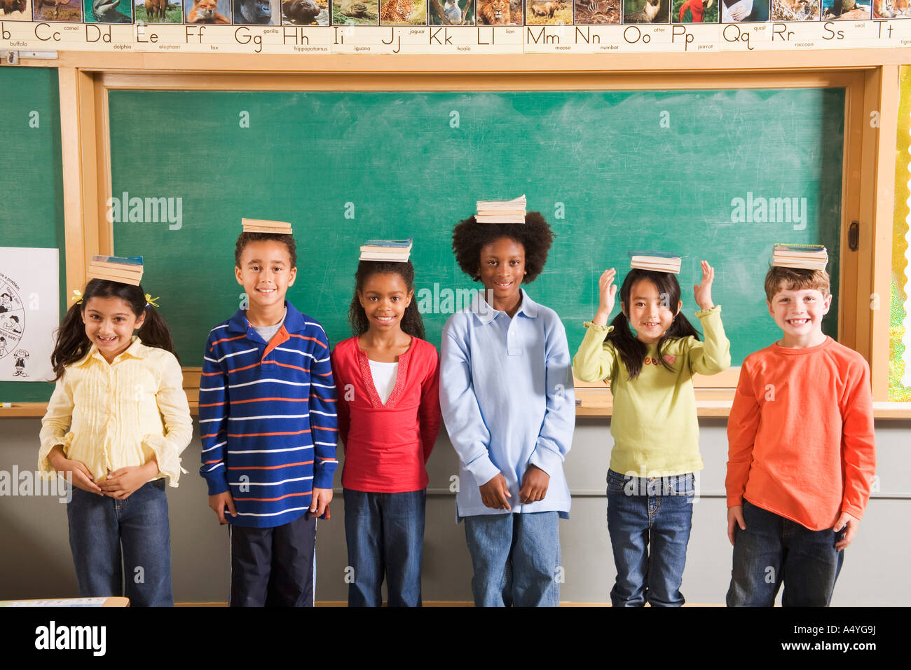 Row of students with books on their heads in classroom Stock Photo - Alamy