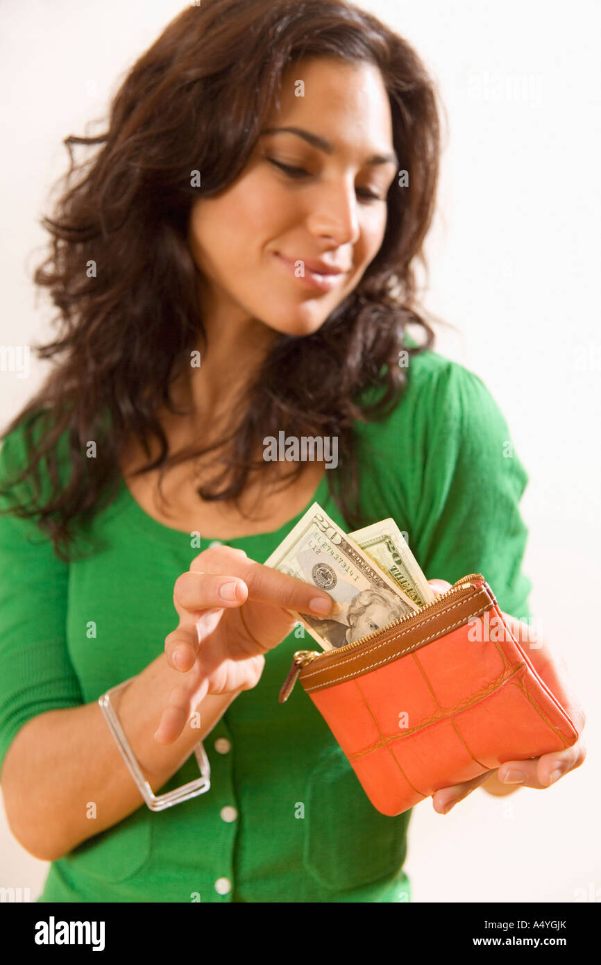 Woman taking money out of wallet Stock Photo - Alamy