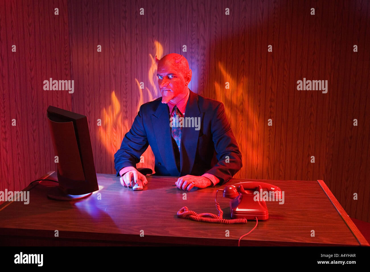 Businessman dressed as devil at desk Stock Photo - Alamy