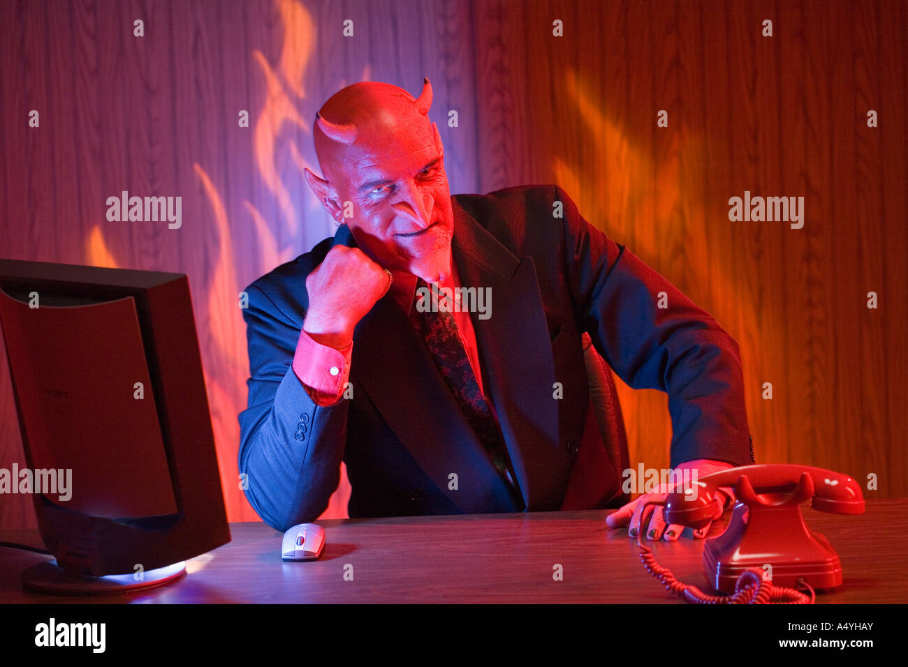 Businessman dressed as devil at desk Stock Photo - Alamy