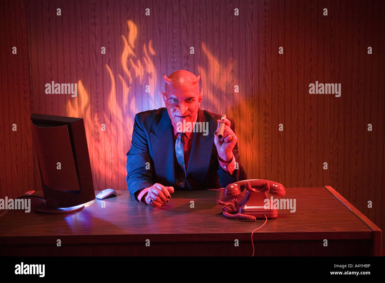 Businessman dressed as devil at desk Stock Photo - Alamy