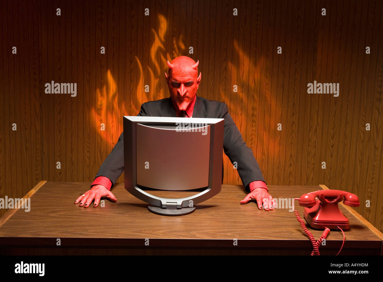 Businessman dressed as devil looking at computer Stock Photo - Alamy