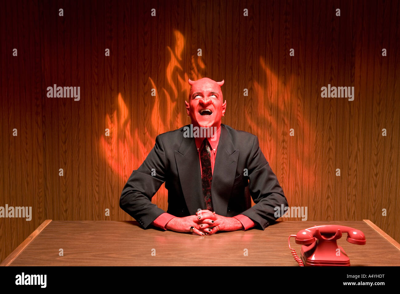 Businessman dressed as devil laughing Stock Photo - Alamy