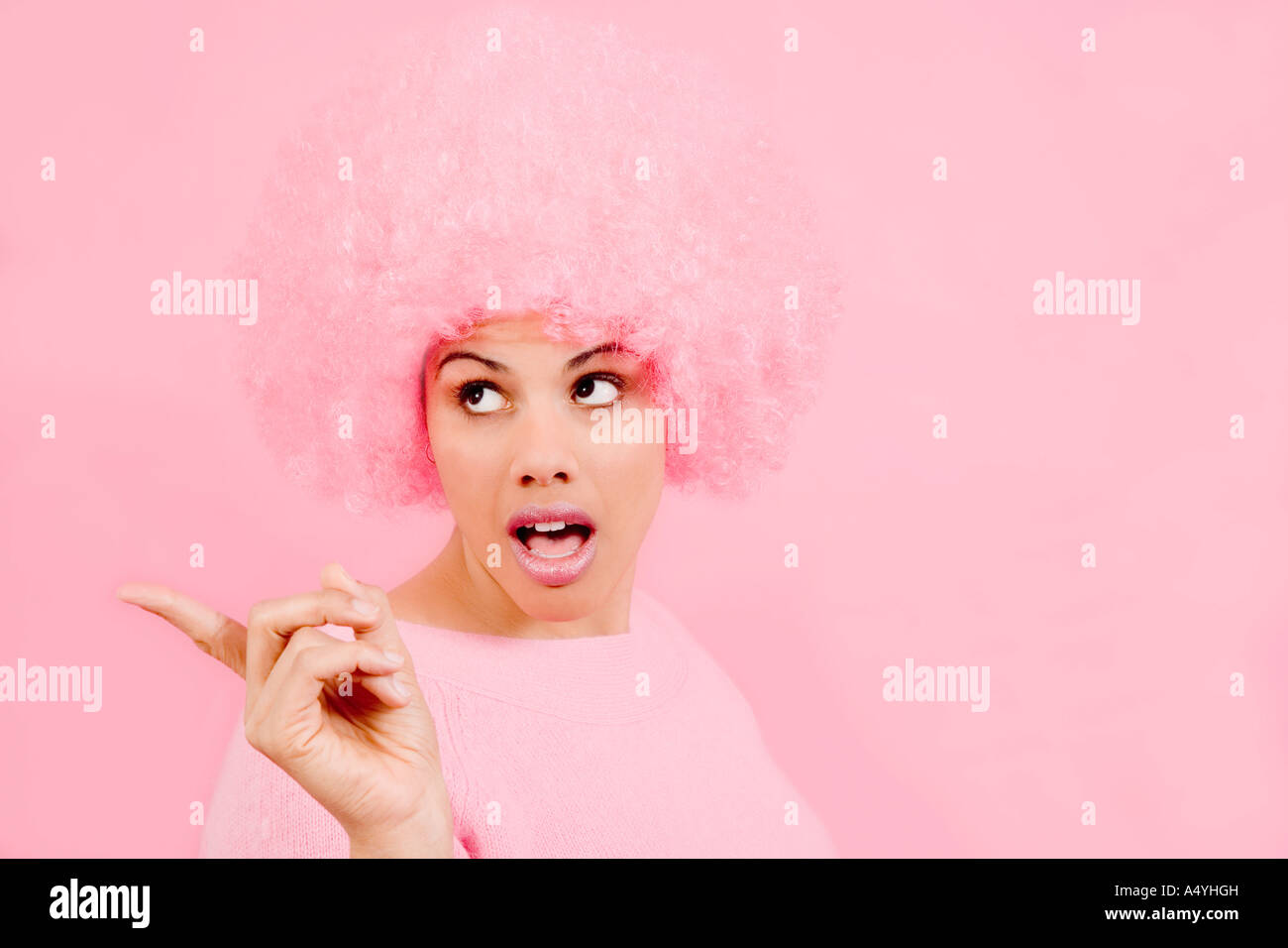Woman wearing pink wig and pointing Stock Photo - Alamy
