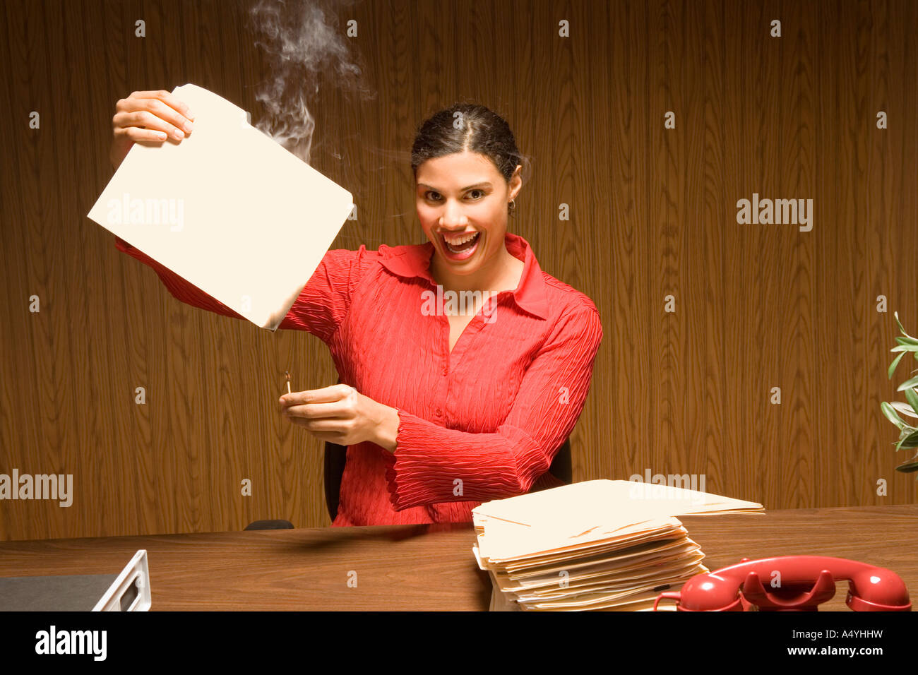 Businesswoman burning files at desk Stock Photo - Alamy