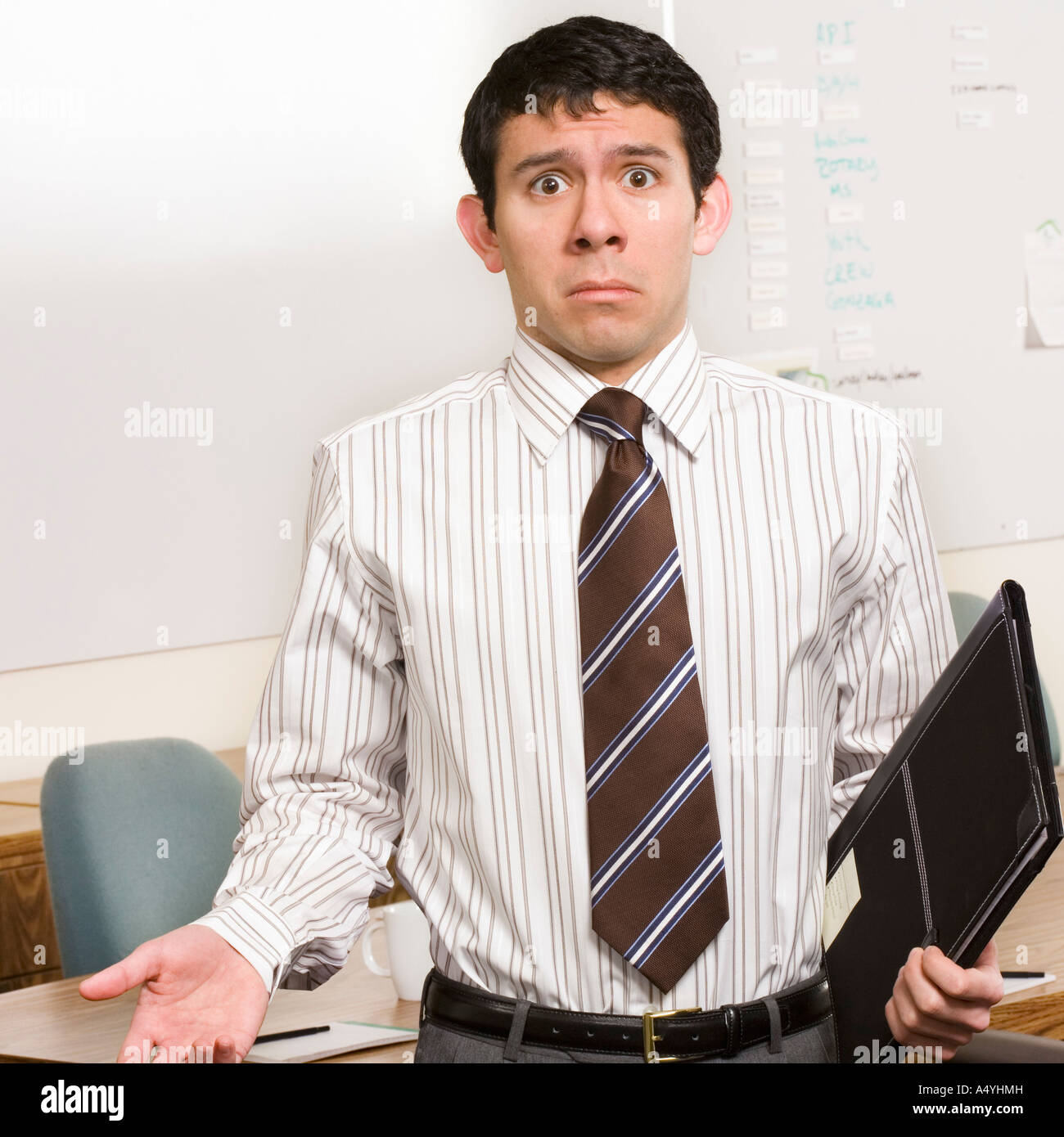 Businessman shrugging shoulders in office Stock Photo - Alamy