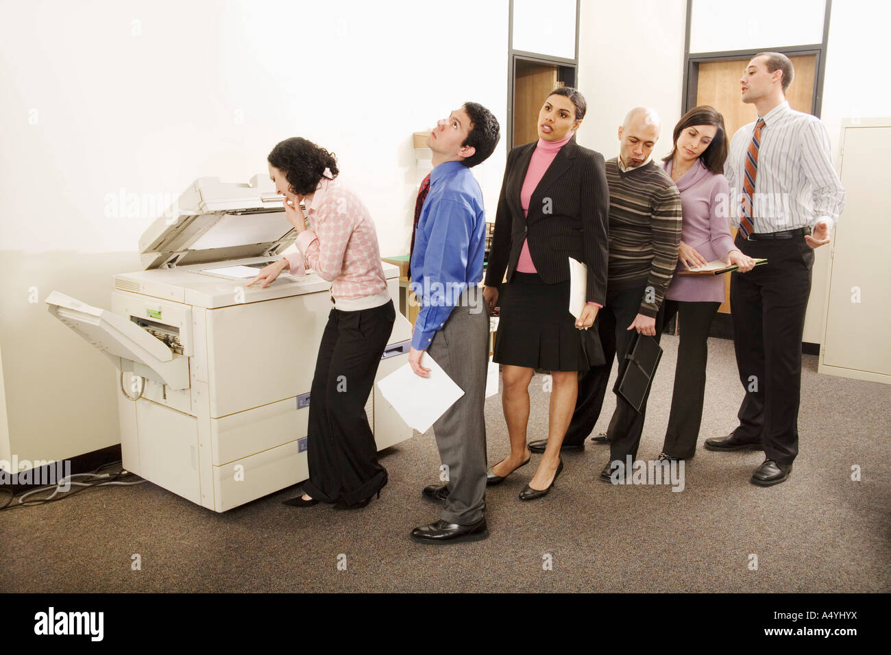 Businesspeople on line to use photocopy machine Stock Photo - Alamy