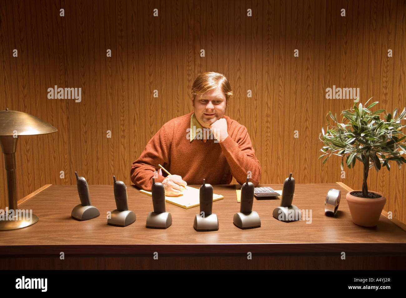 Businessman at desk with multiple telephones Stock Photo - Alamy