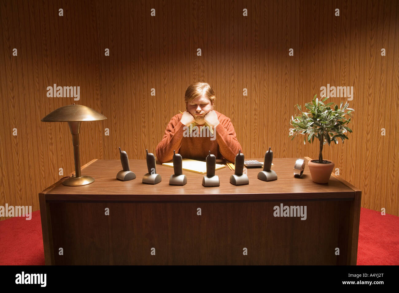 Businessman at desk with multiple telephones Stock Photo - Alamy