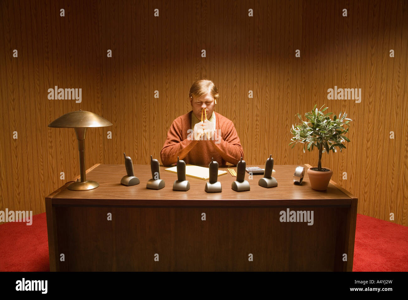 Businessman at desk with multiple telephones Stock Photo - Alamy