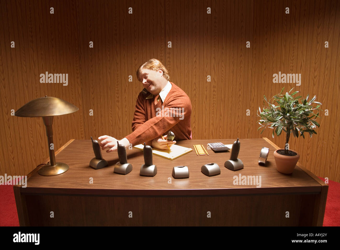 Businessman at desk with multiple telephones Stock Photo - Alamy