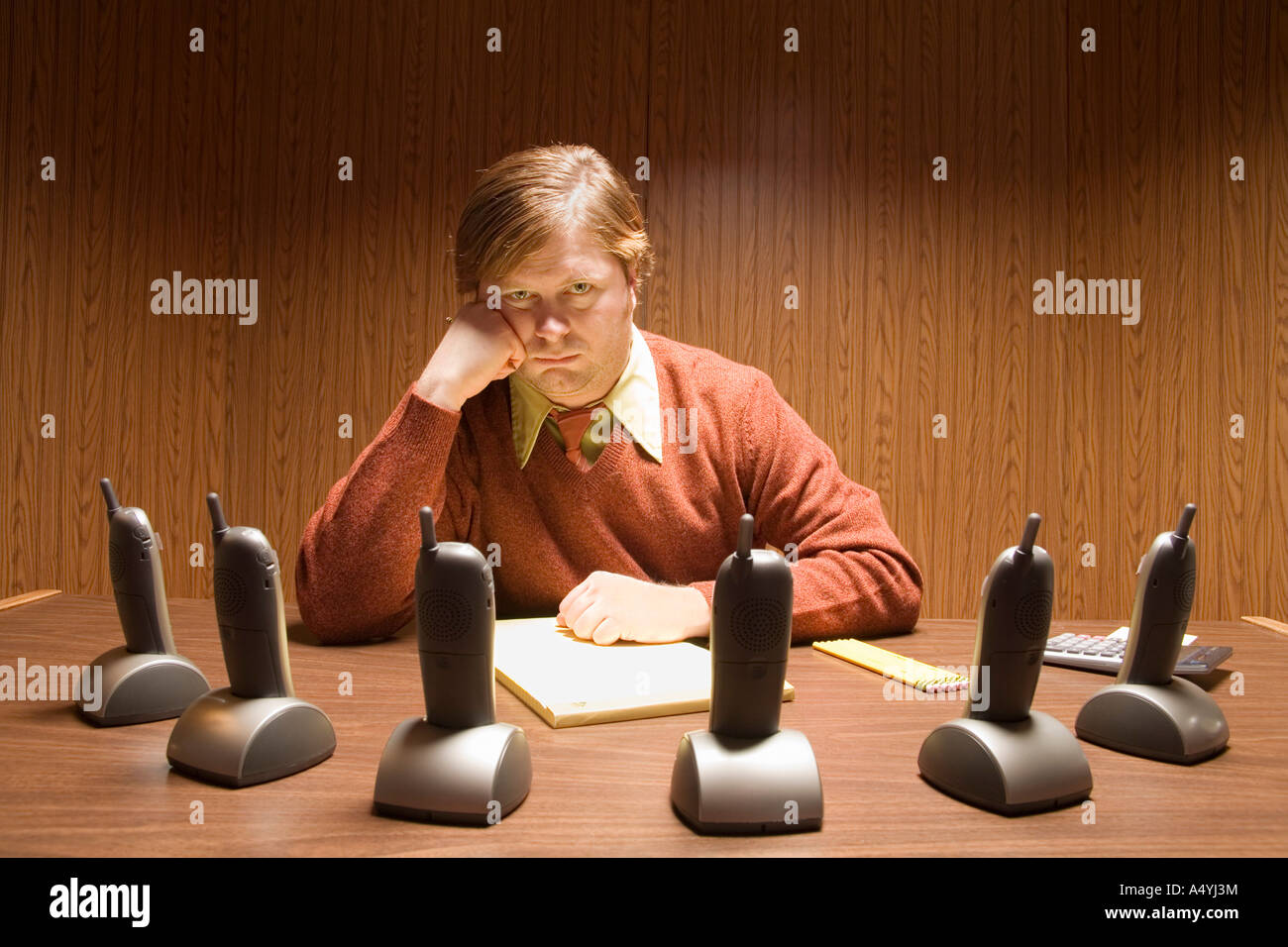 Businessman at desk with multiple telephones Stock Photo - Alamy