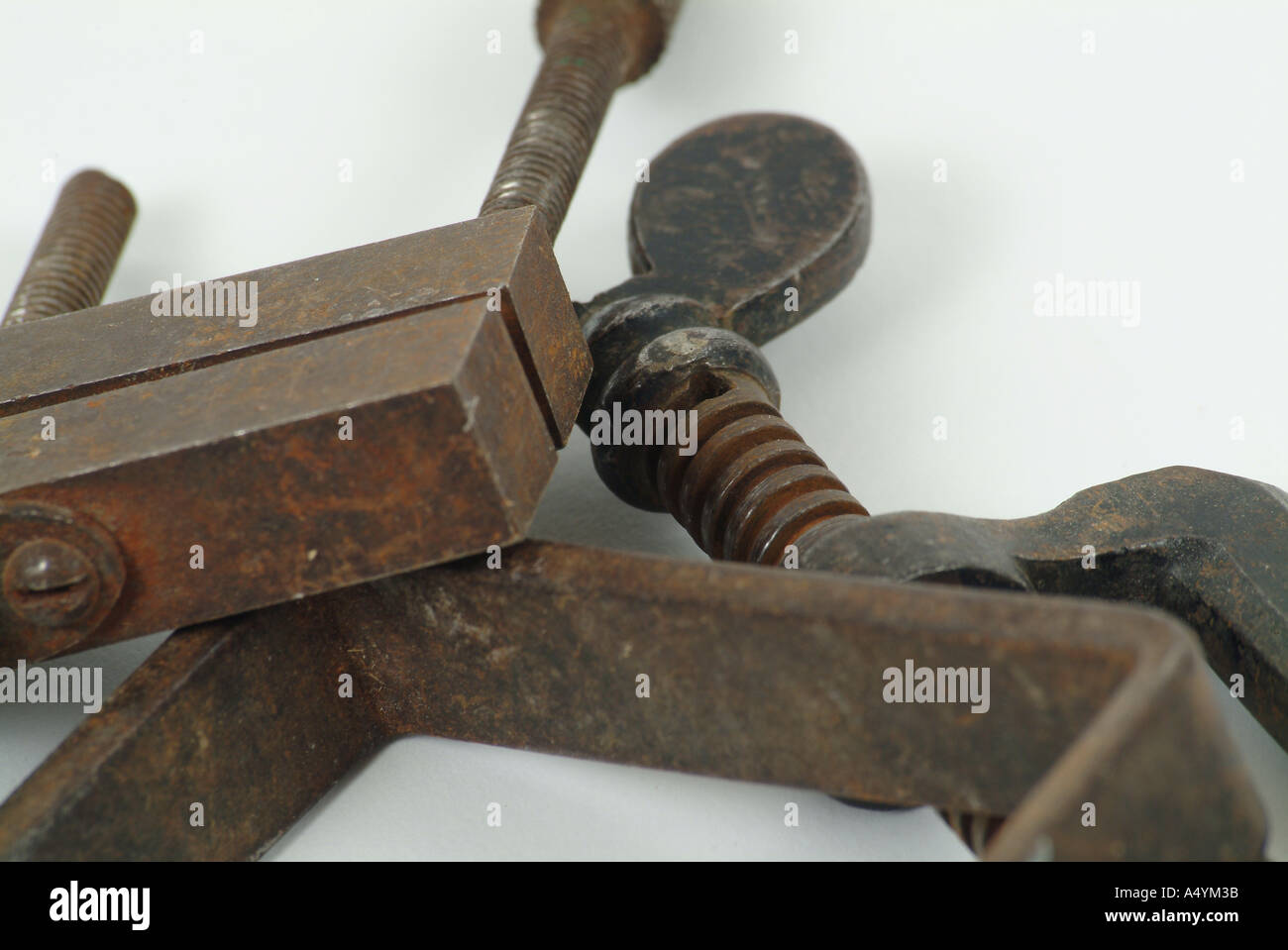 rusty old hand clamps bunched together on a white background Stock ...