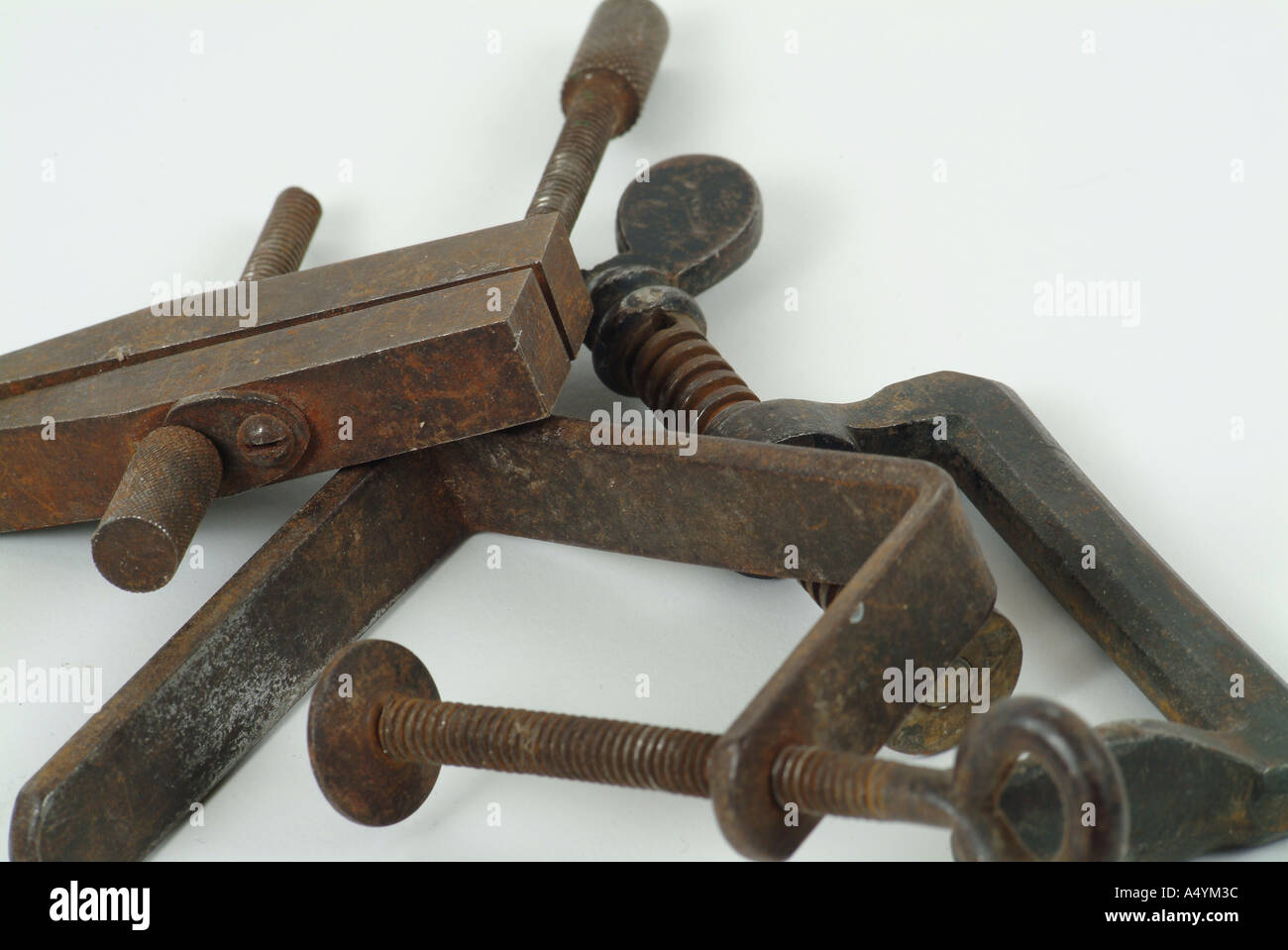 rusty old hand clamps bunched together on a white background Stock ...