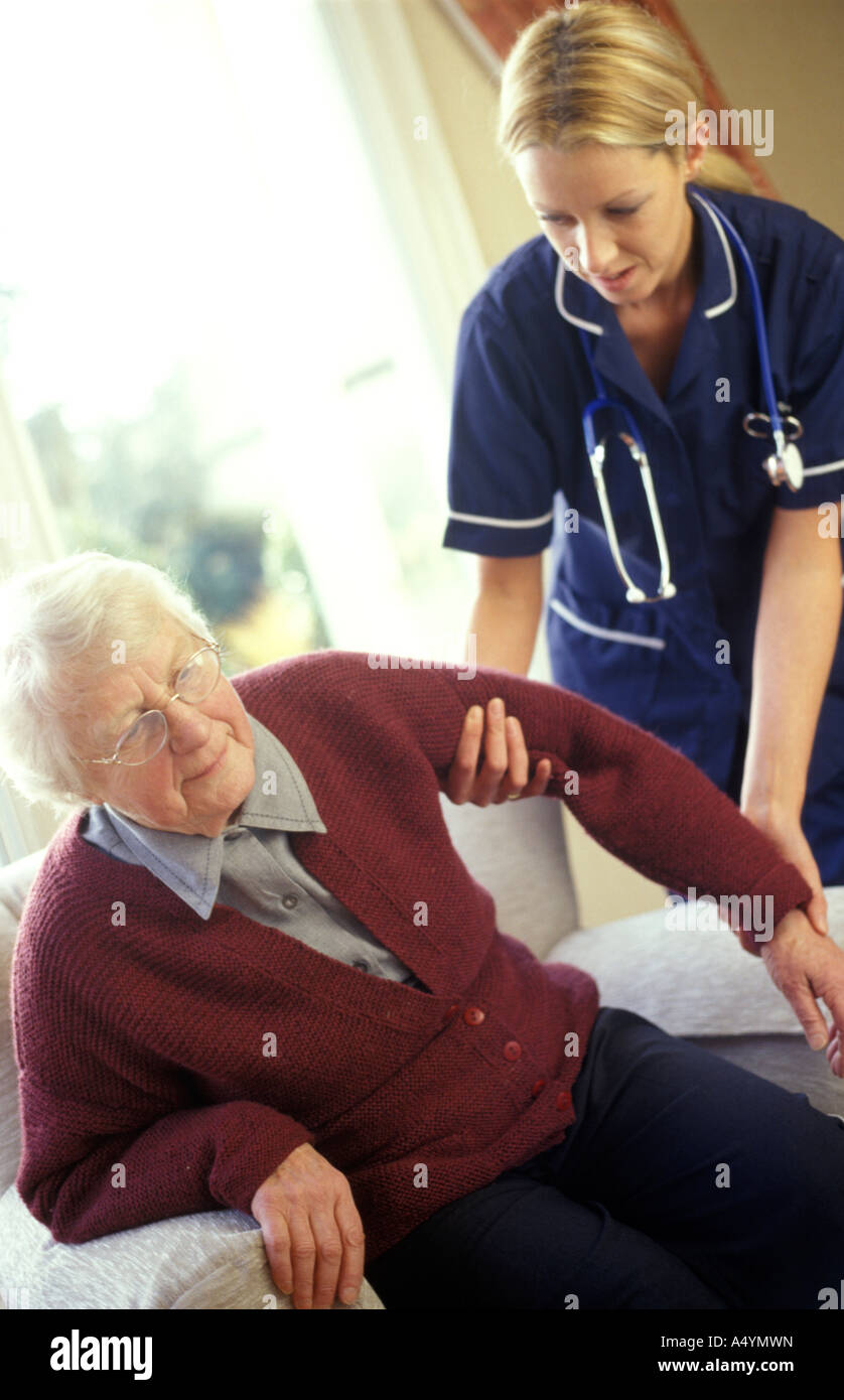 district nurse helping elderly patient on home visit Stock Photo - Alamy