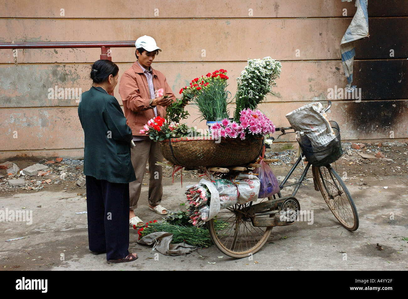 Young man selling seller flowers in the streets of Hanoi Vietnam South ...