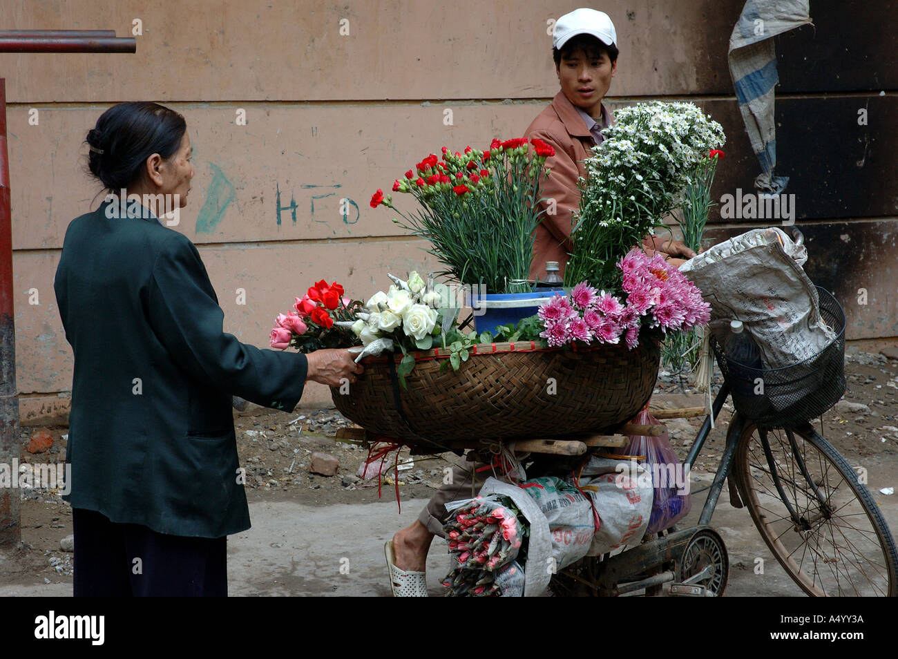 Young man selling seller flowers in the streets of Hanoi Vietnam South ...
