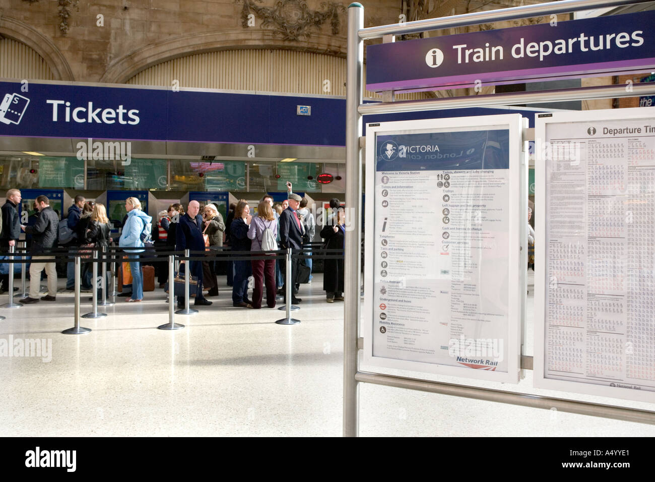 Train departures board and ticket queue at Victoria Station London ...