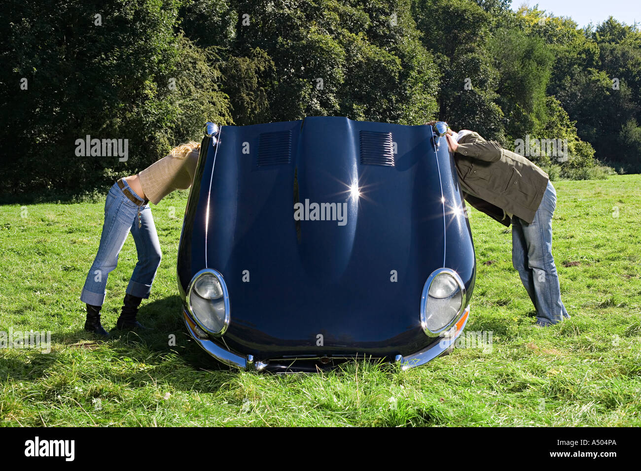 Man woman looking under car hi-res stock photography and images - Alamy