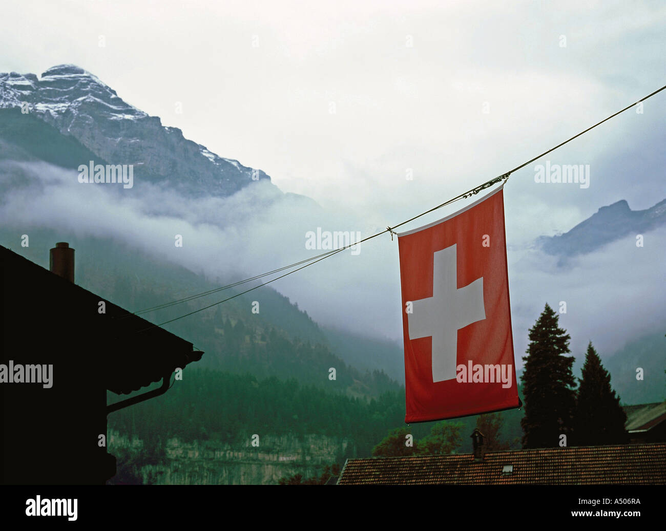 Swiss flag flying with mountains, cloud in back ground Stock Photo - Alamy