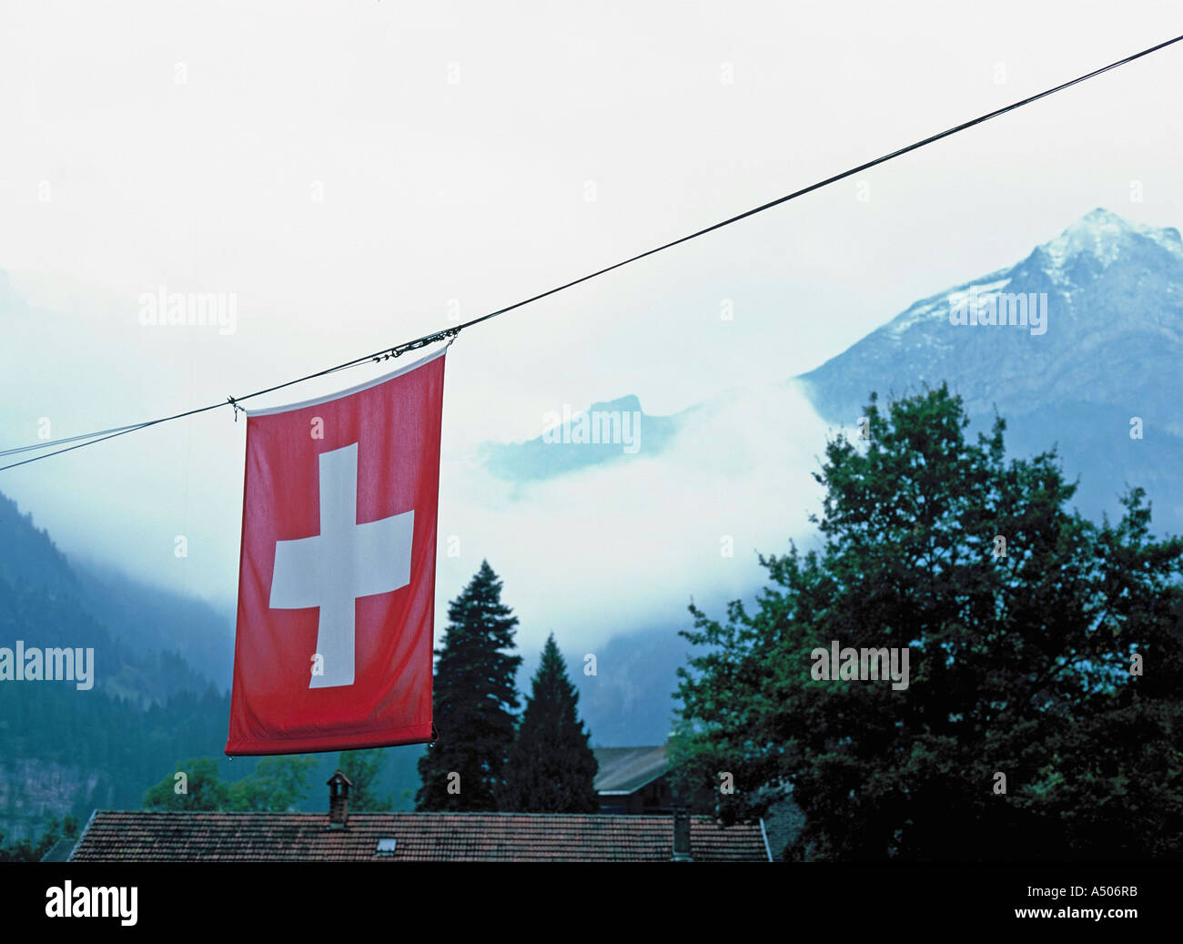 Swiss flag flying with mountains, cloud in back ground Stock Photo - Alamy