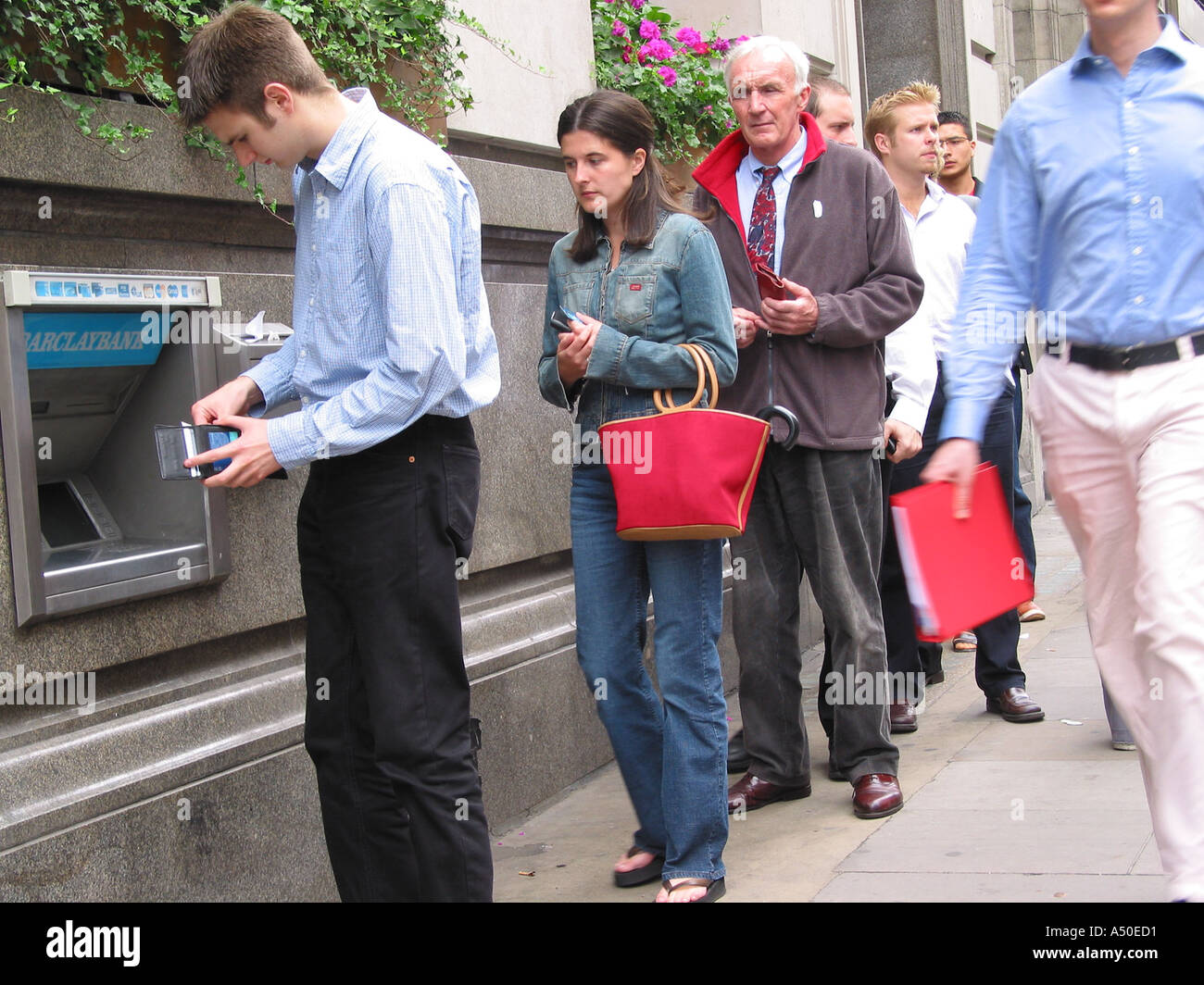 Queue of People at a Cash ATM Machine Stock Photo - Alamy