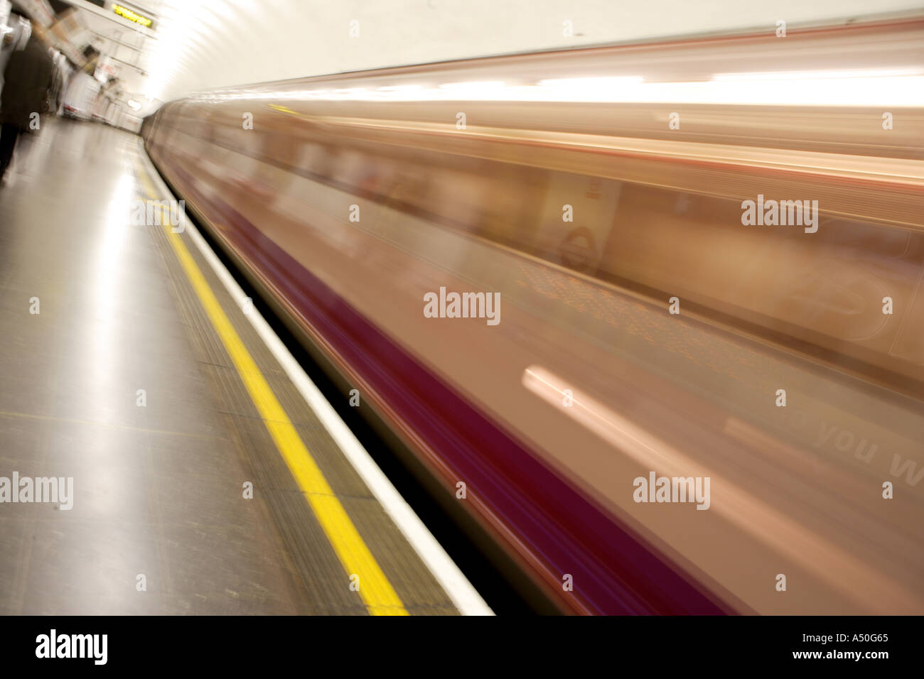 Tube train speeds through a station London England Stock Photo - Alamy