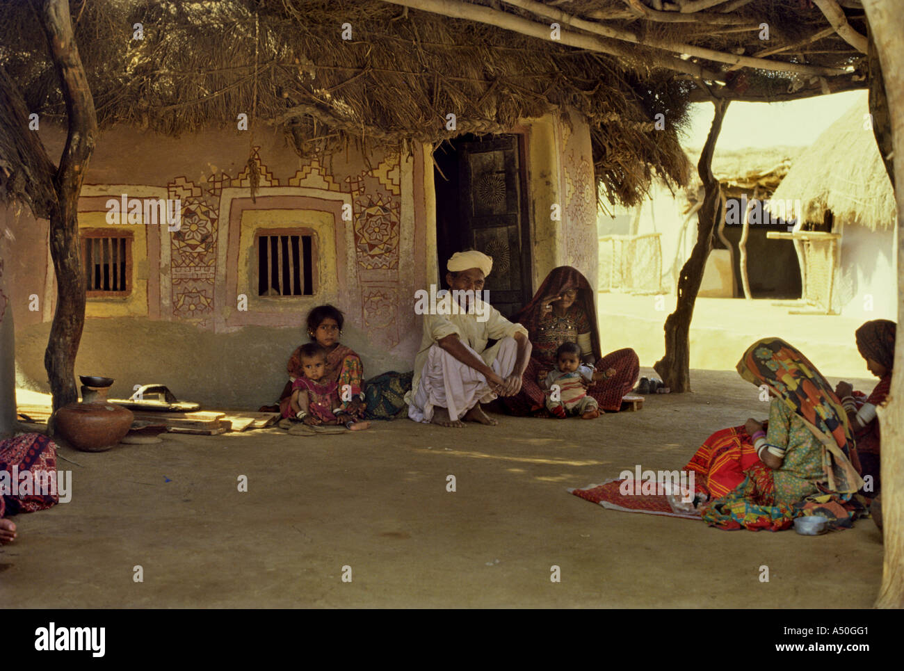 Family sitting outside their hut Stock Photo - Alamy