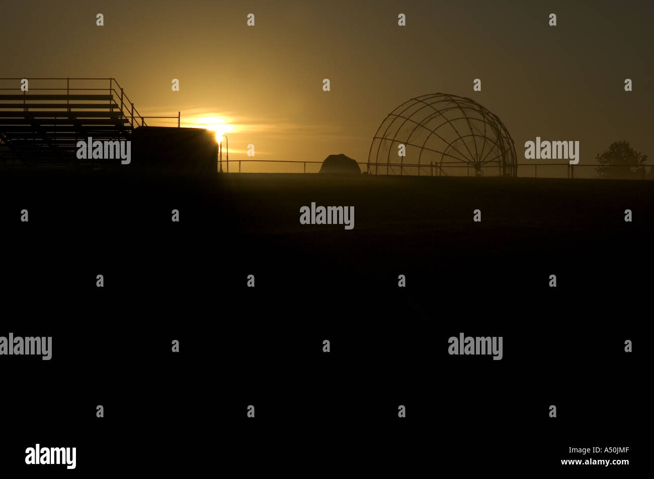 Sunrise over a sports field. Baseball field and bleachers Stock Photo ...