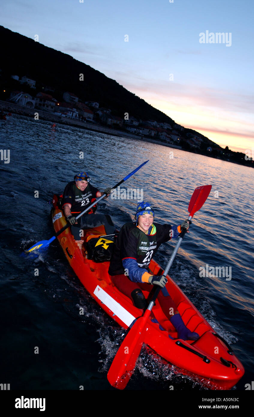 Adventure race athletes paddling kayaks at sunset Stock Photo - Alamy