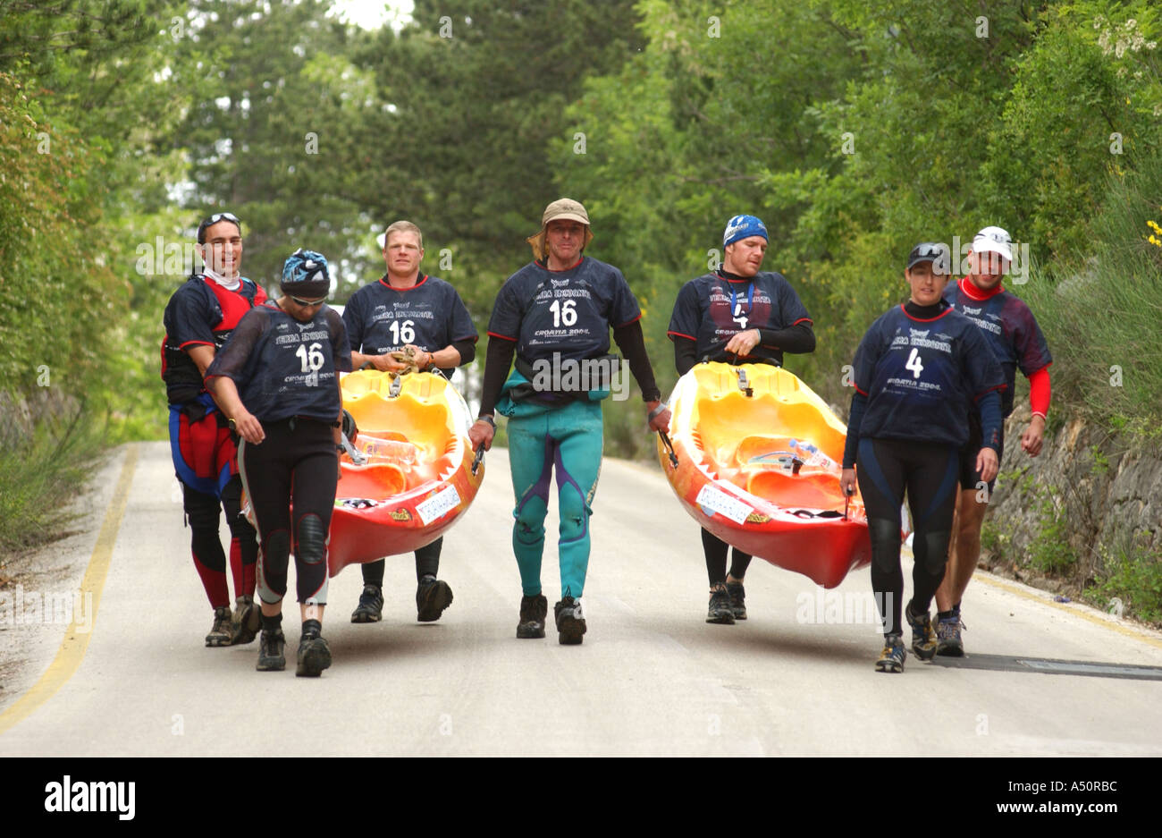 Adventure race athletes portage kayaks Stock Photo - Alamy