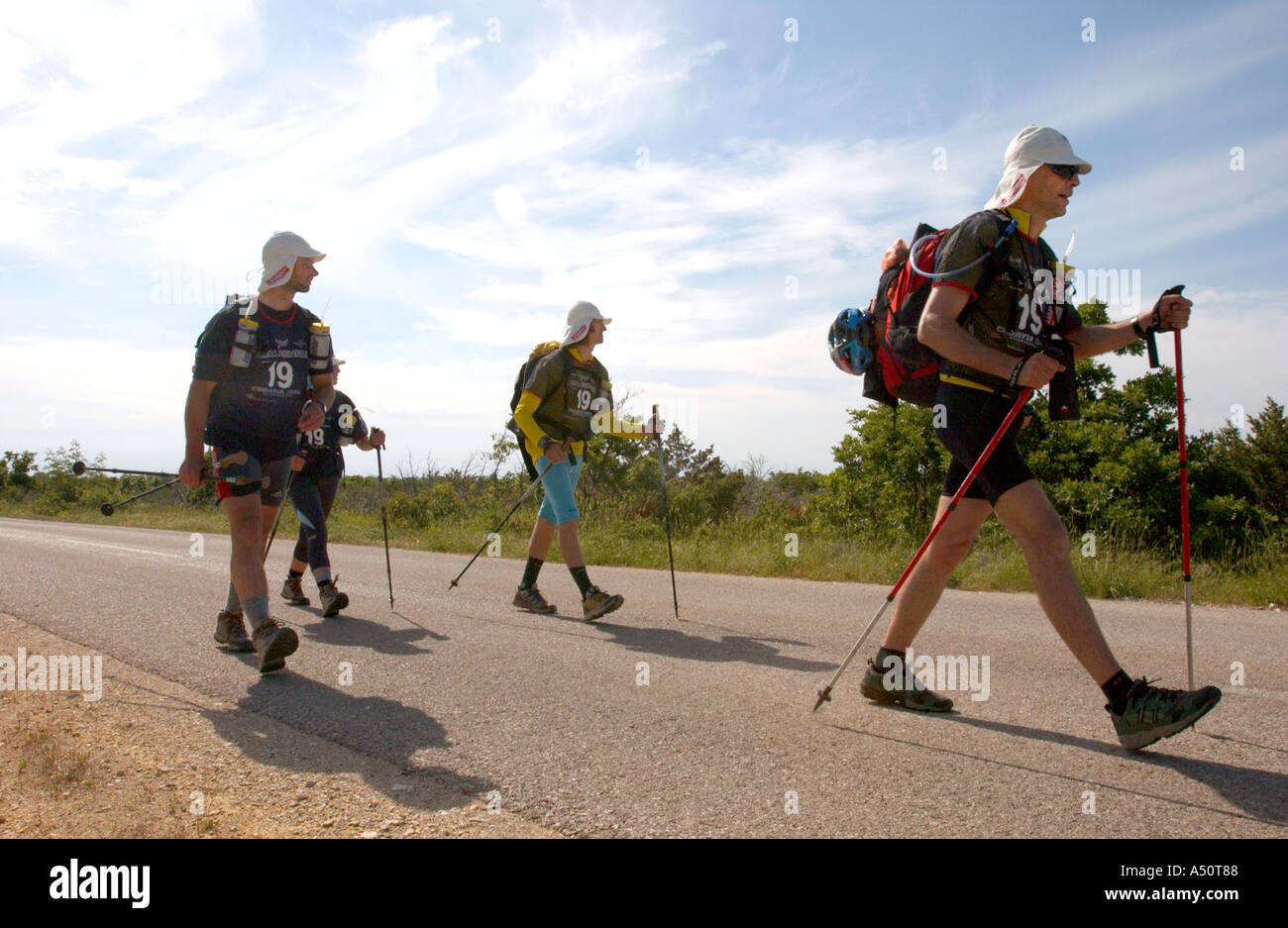 Adventure race team trekking in hot sun Stock Photo - Alamy