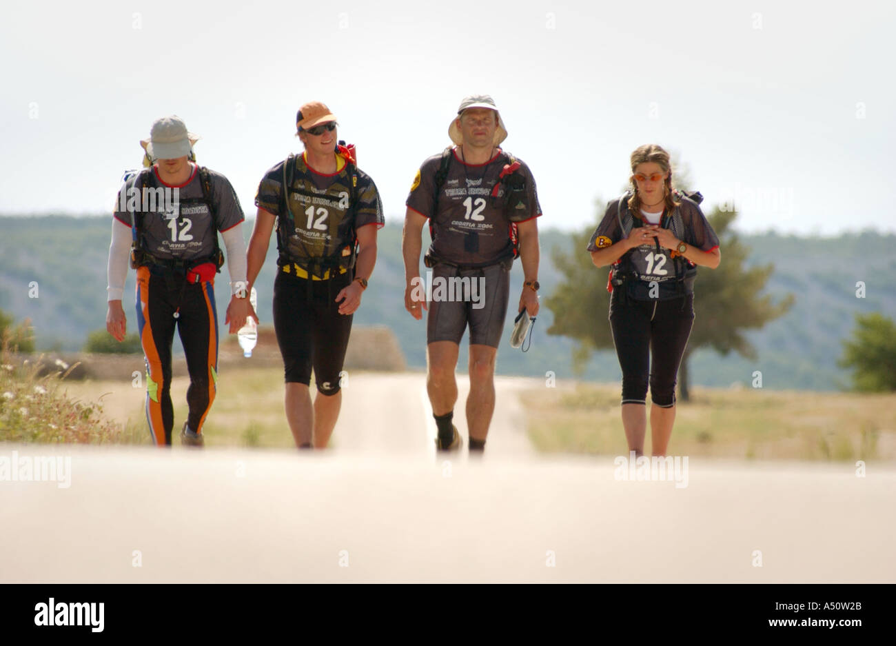 Adventure race team trekking in hot sun Stock Photo - Alamy