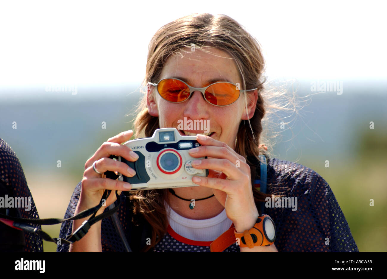Female adventure race athlete takes photograph with waterproof camera ...