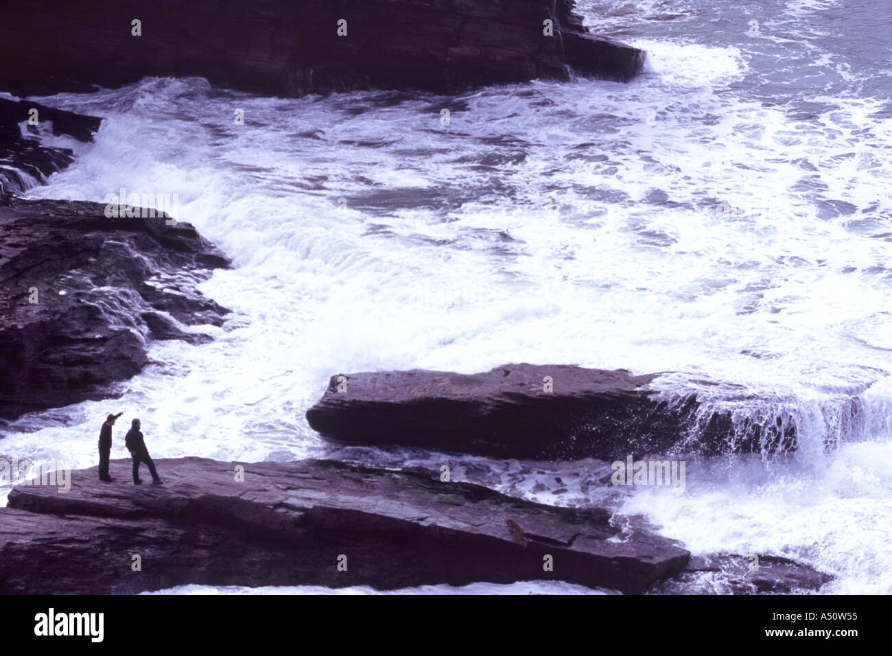 Men on Rocks by Sea Stock Photo - Alamy