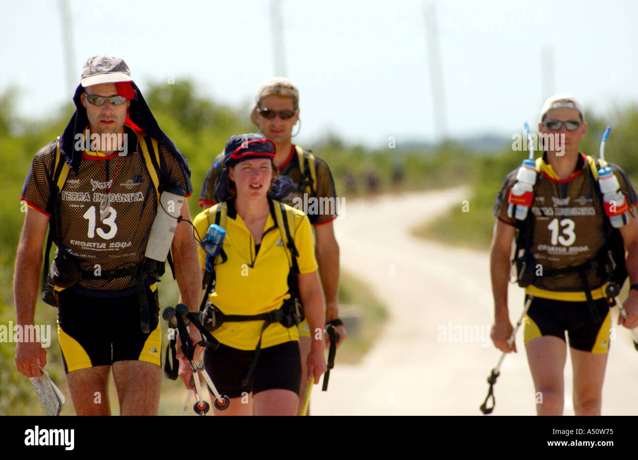 Adventure race team trekking in hot sun Stock Photo - Alamy