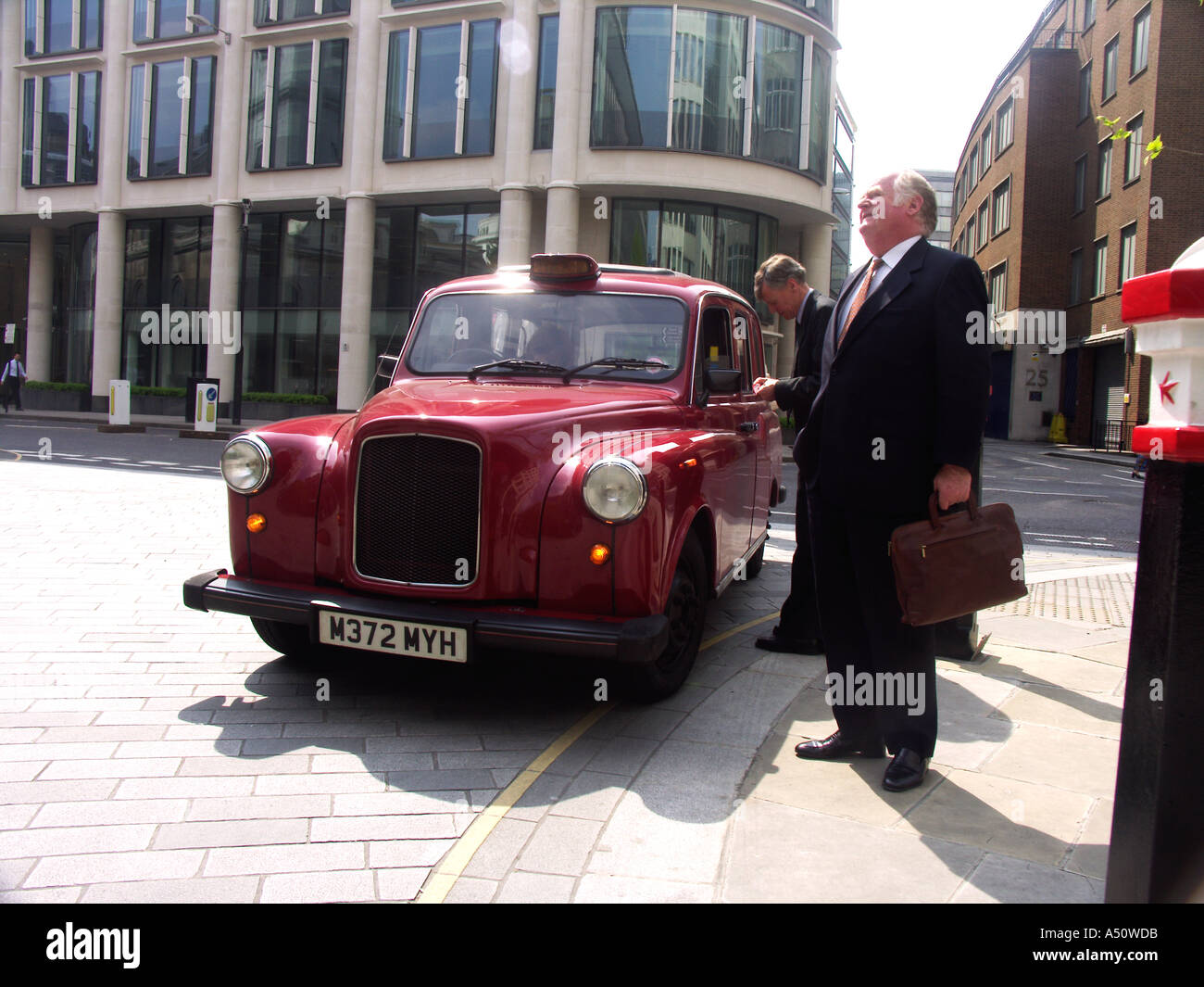 Two businessmen red taxi City of London England Stock Photo - Alamy
