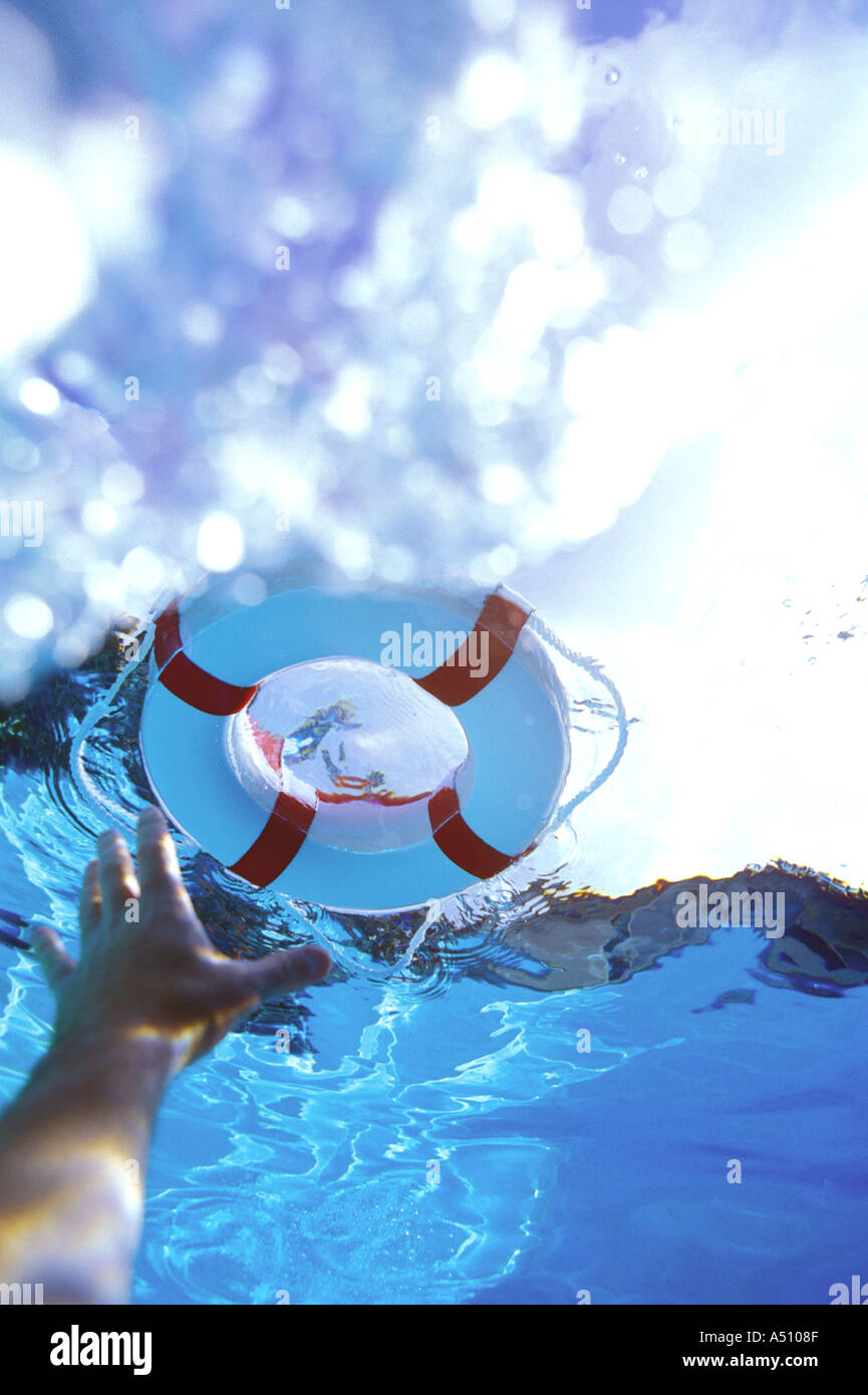 Swimmers hand reaching up toward life saving ring floating on surface ...