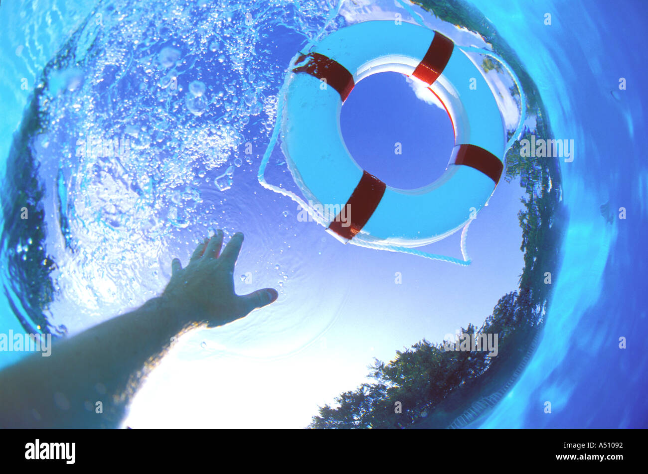 Swimmers hand reaching up toward life saving ring floating on surface ...