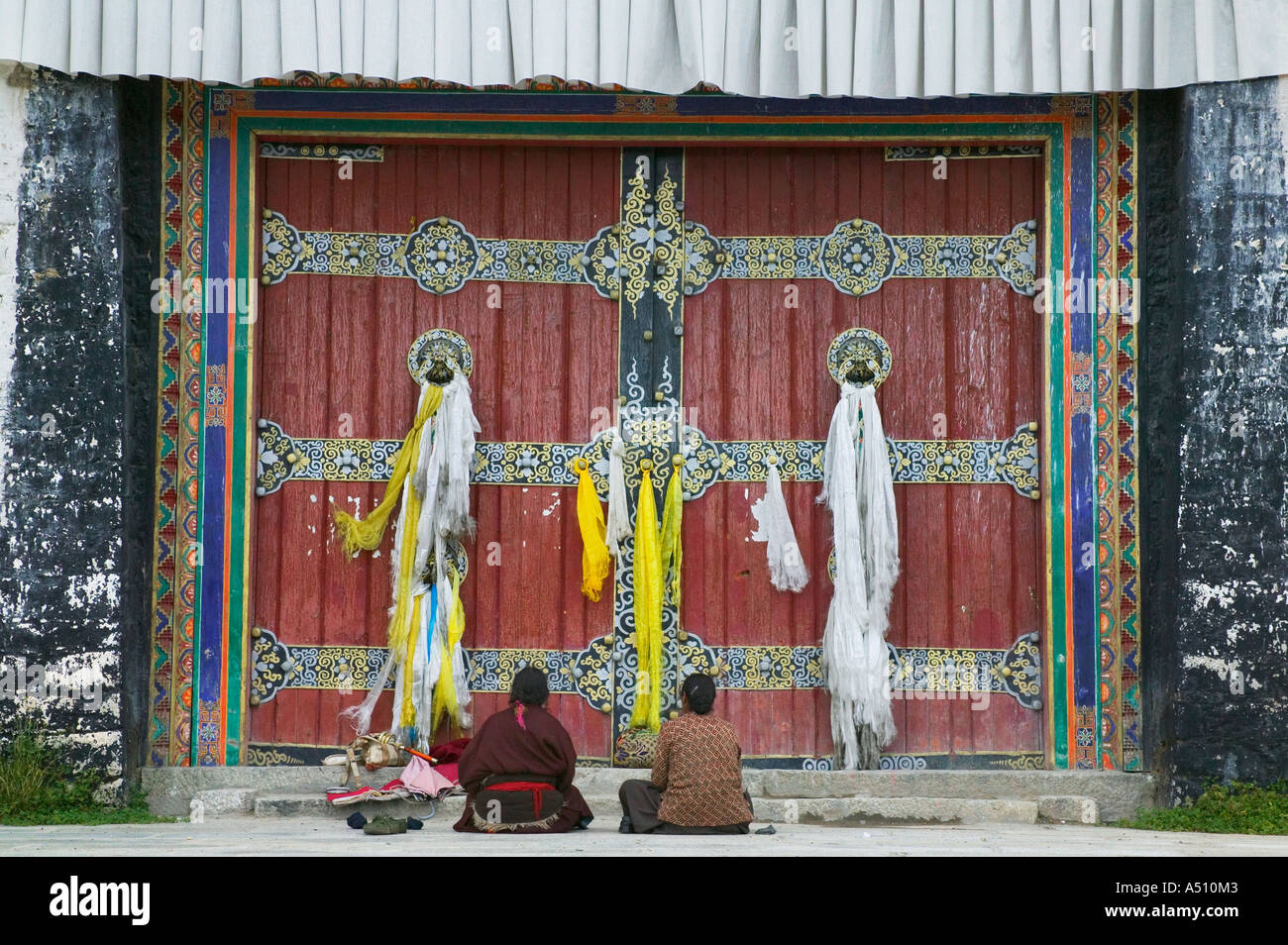 Tibetan pilgrims with traditional gate inside Potala Palace Lhasa Tibet ...