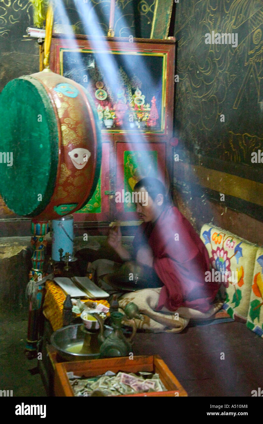 Monk chanting with drum in Potala Palace sunlight coming through the ...